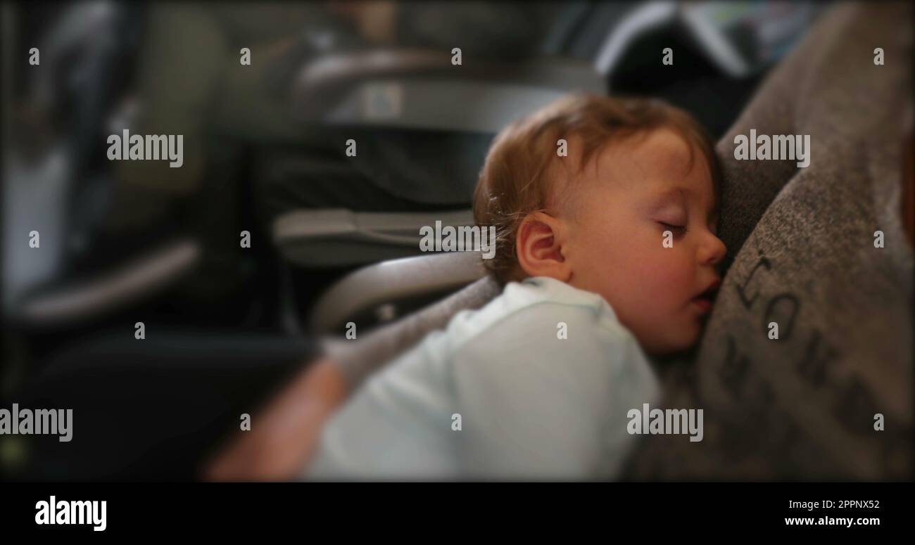 Baby sleeping inside airplane, parent holding infant toddler asleep ...