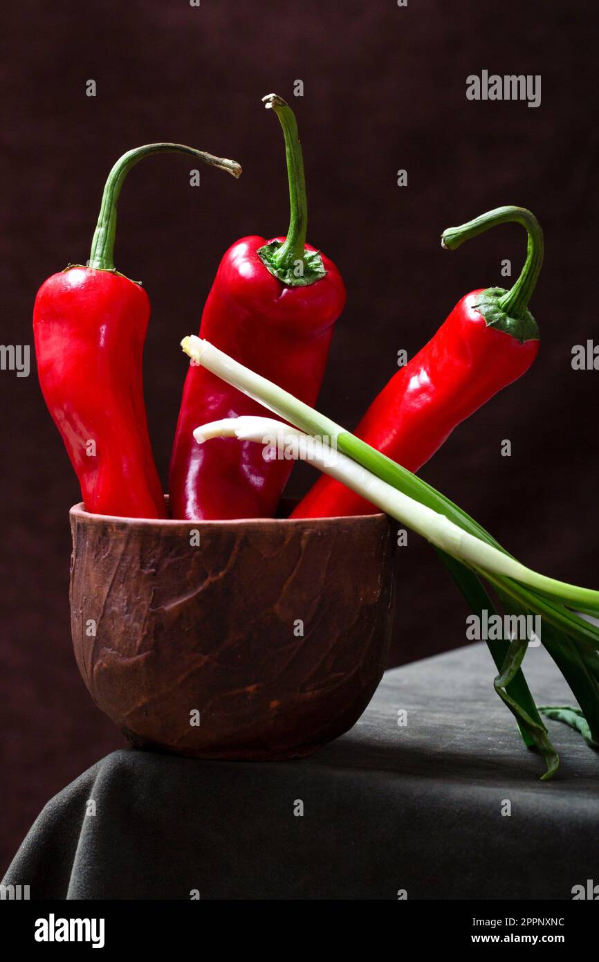 Still life with red pepper in a cup and onions on the table Stock Photo ...