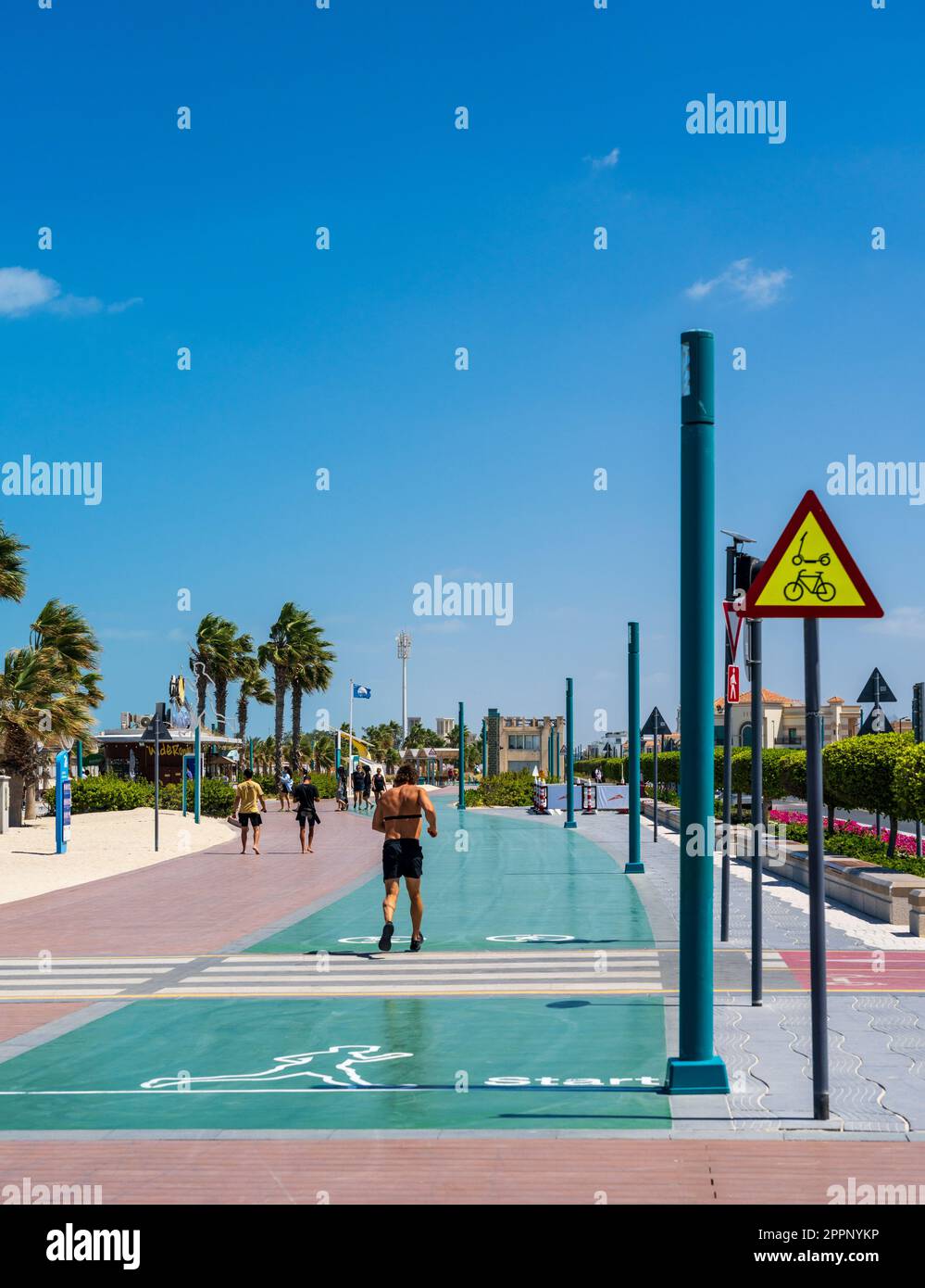 Dubai, UAE - 3 April 2023: Man jogging along green Zero Point running ...