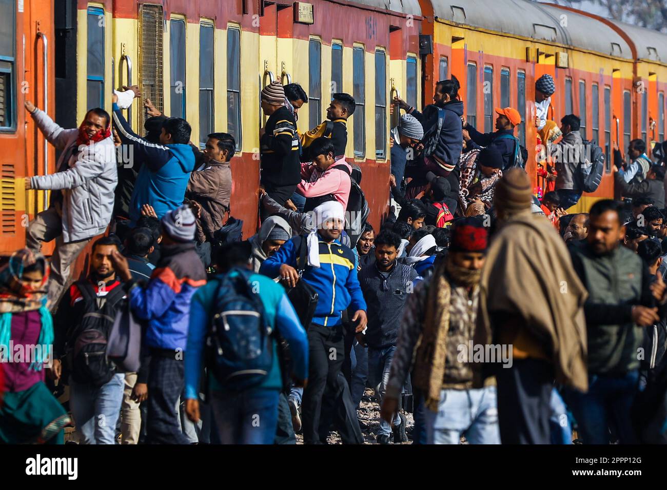 Indian passengers cling to a crowded train as it leaves Noli station in ...