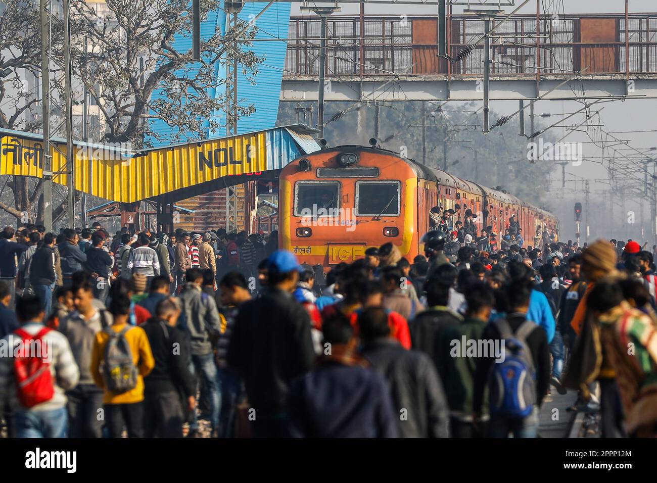 Indian passengers cling to a crowded train as it leaves Noli station in ...