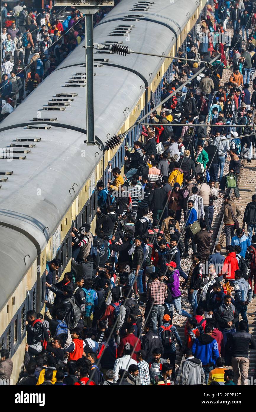 Indian passengers cling to a crowded train as others wait to board at ...
