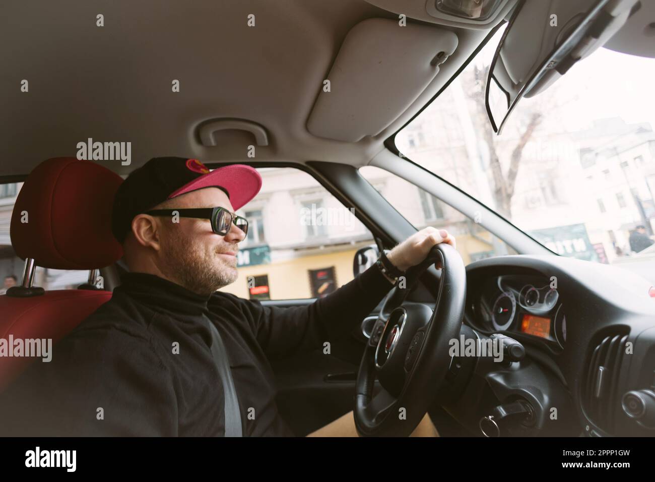 The man with glasses and cap driving car Stock Photo - Alamy