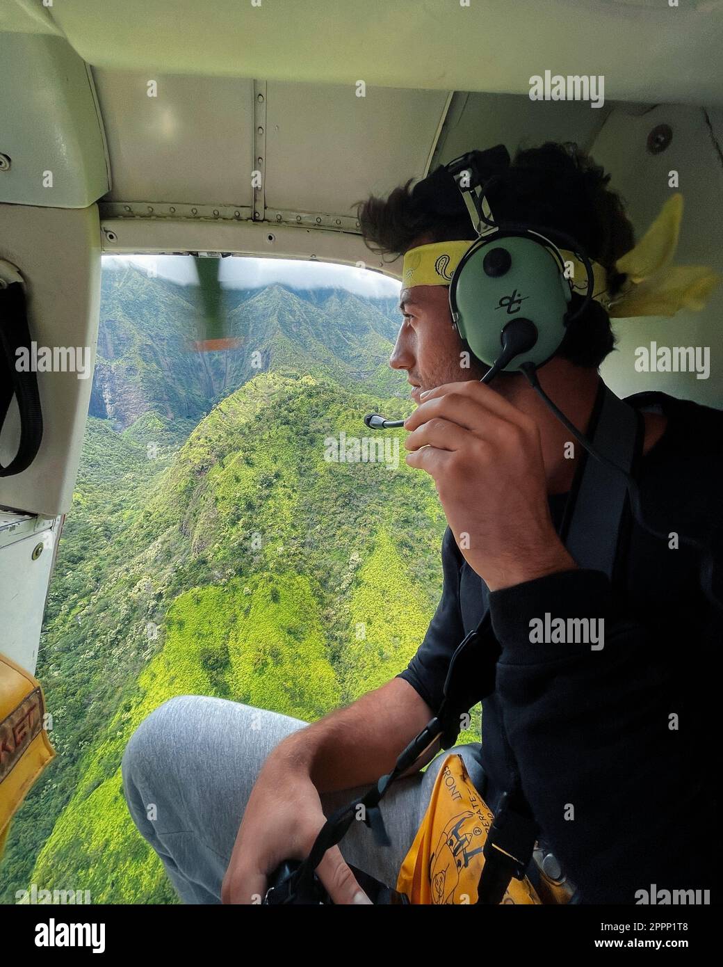Open door helicopter tour above Hawaii with man looking out Stock Photo ...