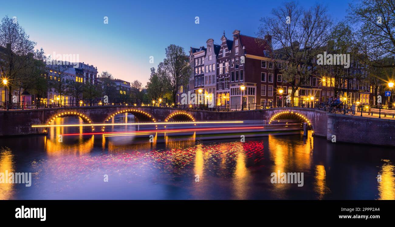 A cityscape of Amsterdam in the Netherlands at dusk, illuminated by ...