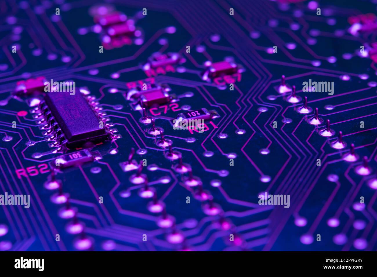 A close-up macro shot of a complex circuit board with various electronic components and ...