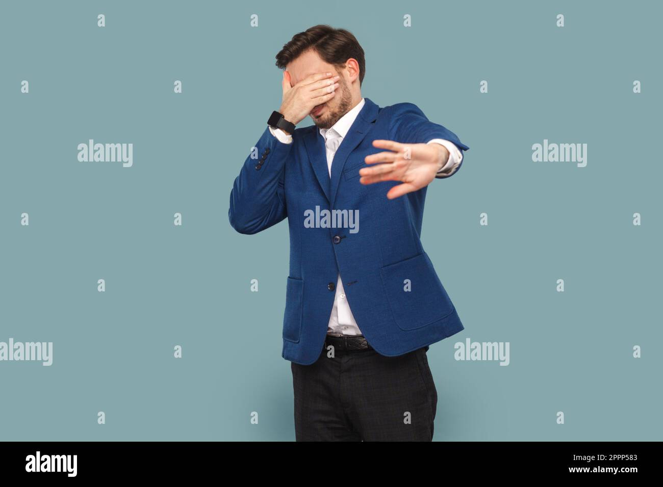 Portrait of man with mustache standing and covering eyes with palm ...