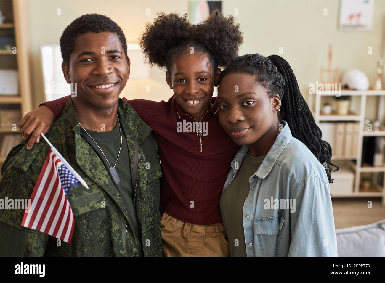 Portrait of happy family with their military dad smiling at camera ...