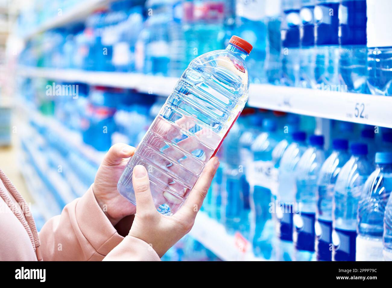 Plastic bottle drinking water in hands buyer in store Stock Photo - Alamy