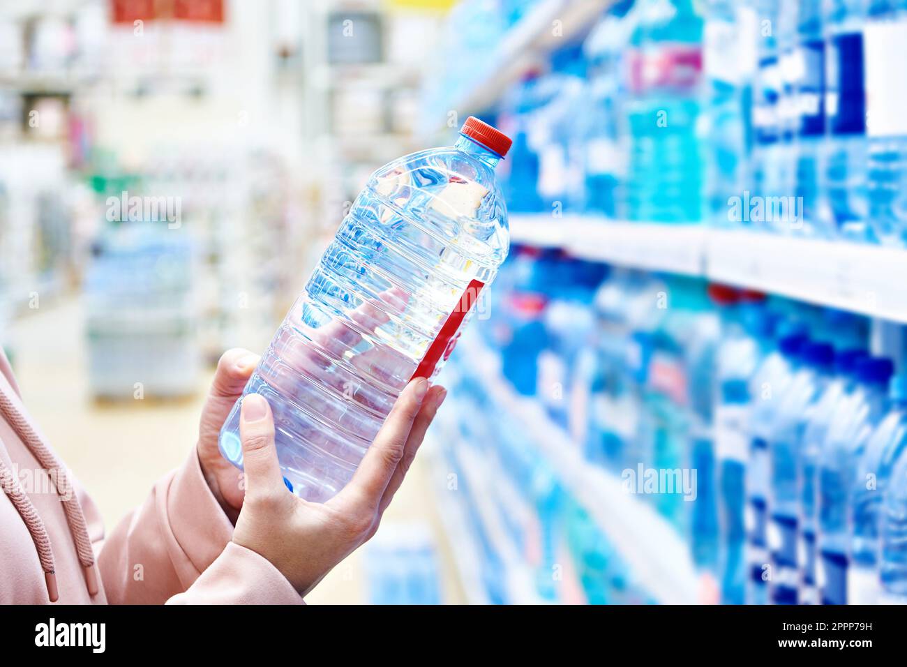 Plastic bottle drinking water in hands buyer in store Stock Photo - Alamy