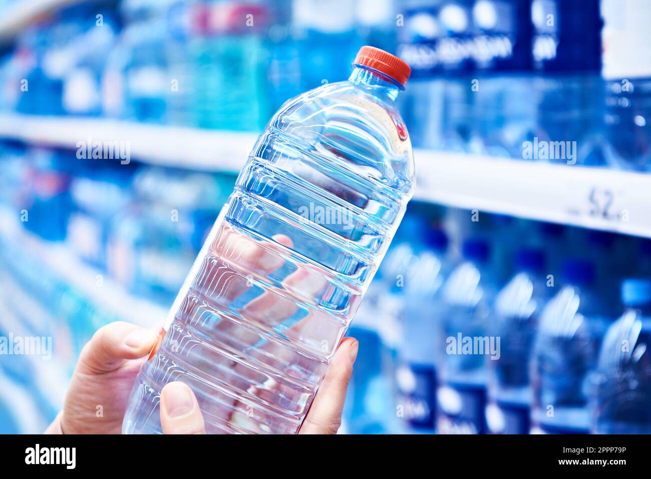 Plastic bottle drinking water in hands buyer in store Stock Photo - Alamy