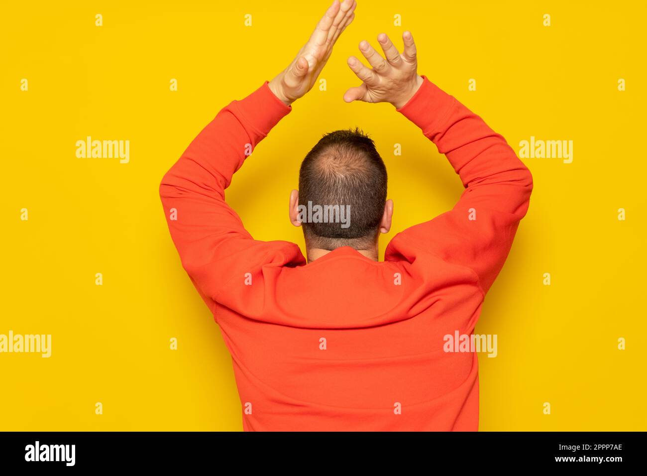 Half-bald man energetically clapping his back, he is excited about the ...