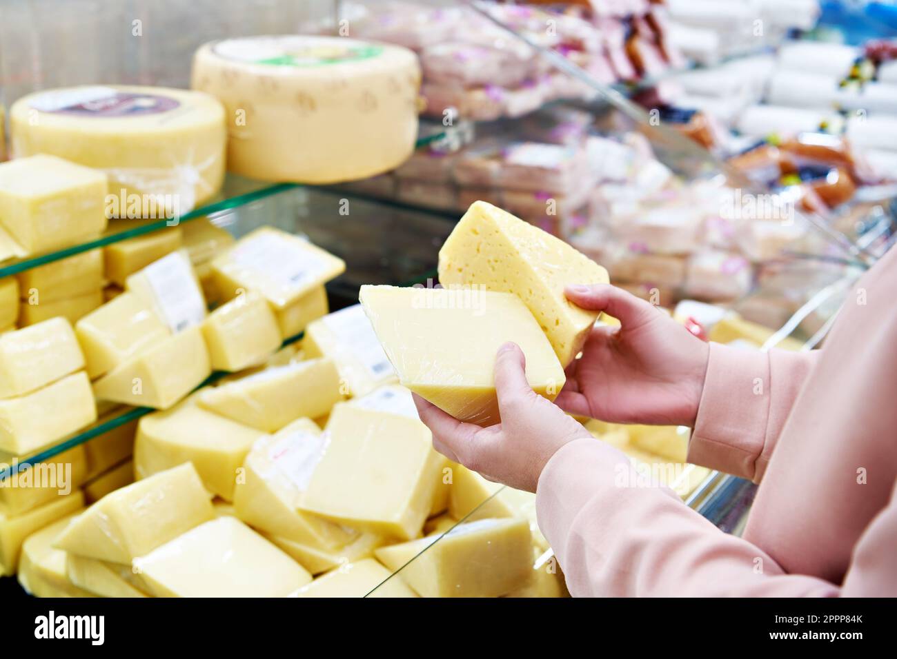 Hands with a pieces of cheese in supermarket Stock Photo - Alamy