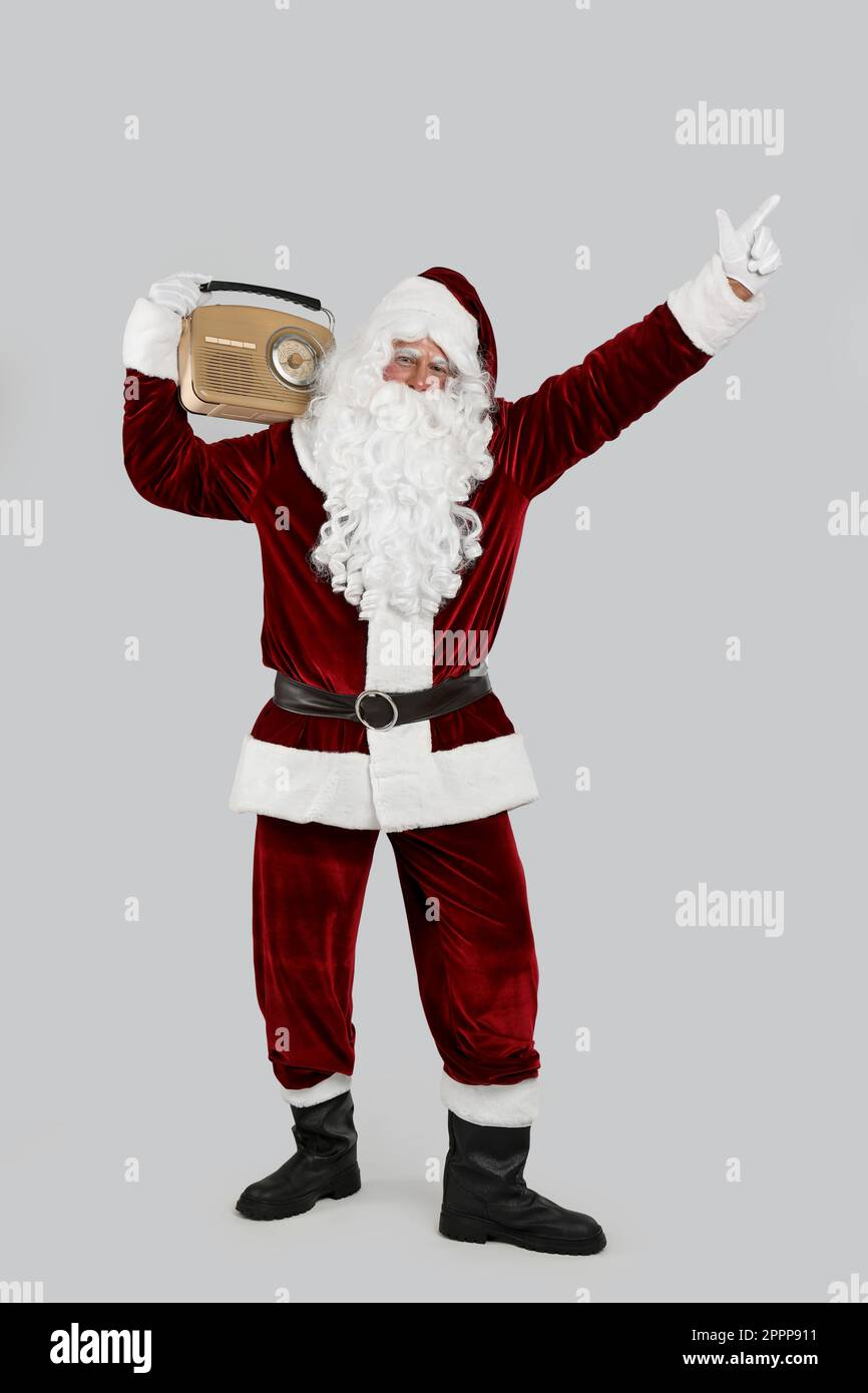 Santa Claus with vintage radio on light grey background. Christmas ...