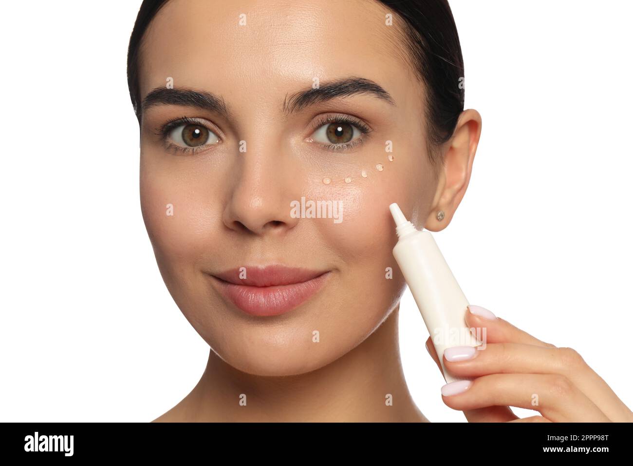 Beautiful young woman applying gel on skin under eye against white ...