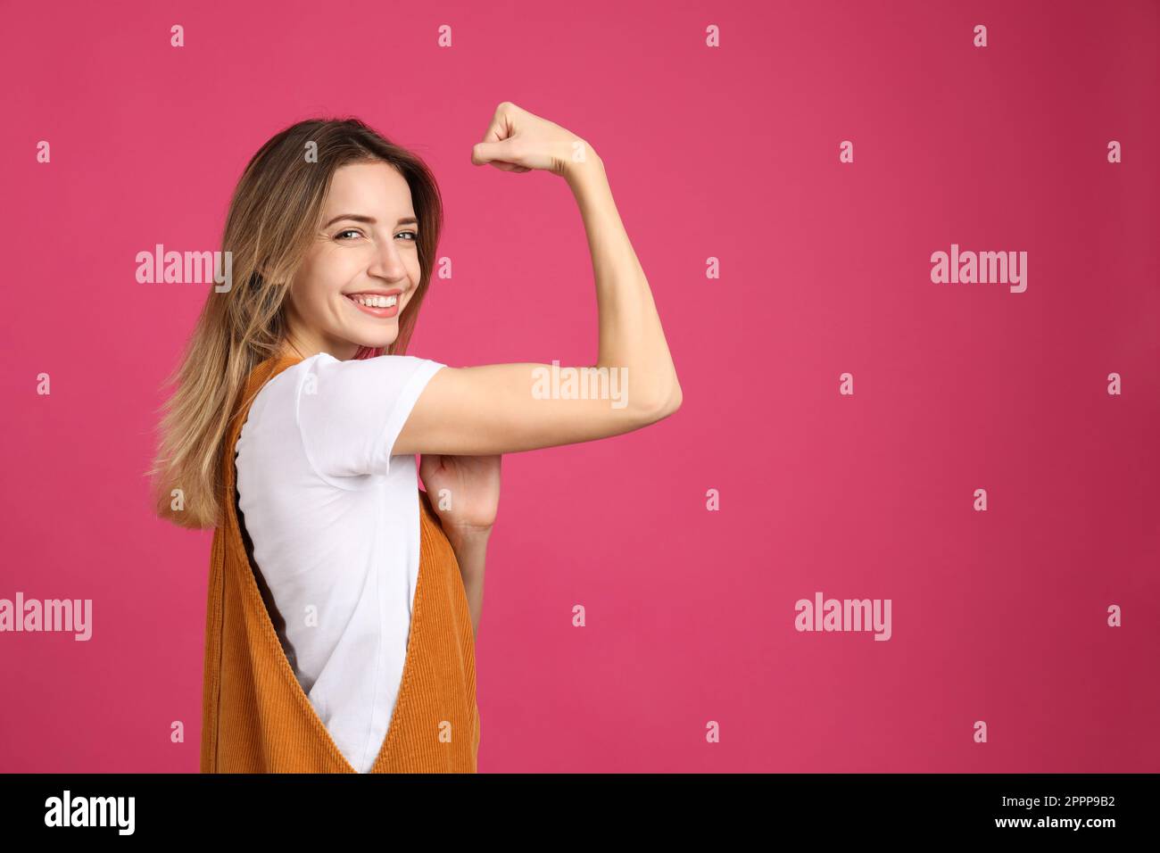 Strong woman as symbol of girl power on pink background, space for text ...