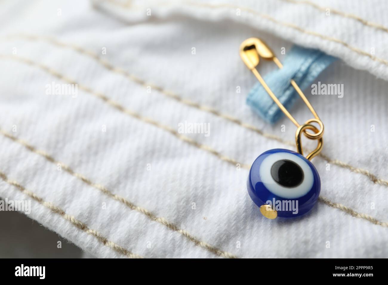 Evil eye safety pin on clothing, closeup Stock Photo - Alamy