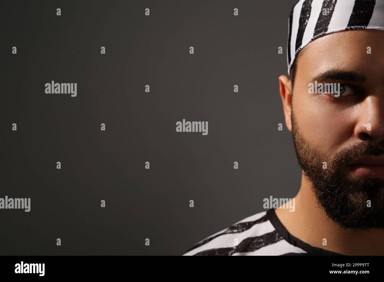 Prisoner in special uniform on dark grey background, closeup. Space for ...