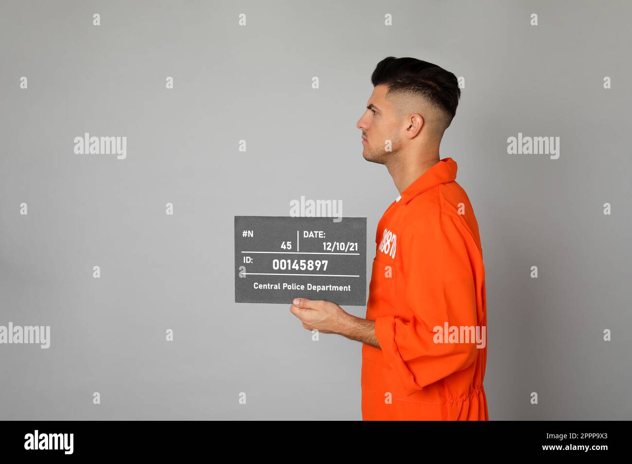 Mug shot of prisoner in orange uniform with board on grey background ... Mug shot of prisoner in orange uniform with board on grey background ...