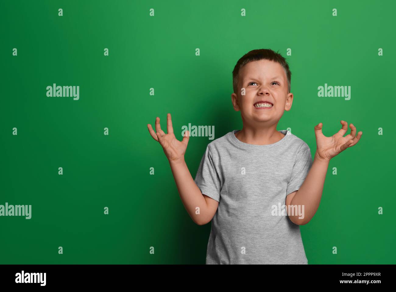 Angry little boy on green background, space for text. Aggressive ...