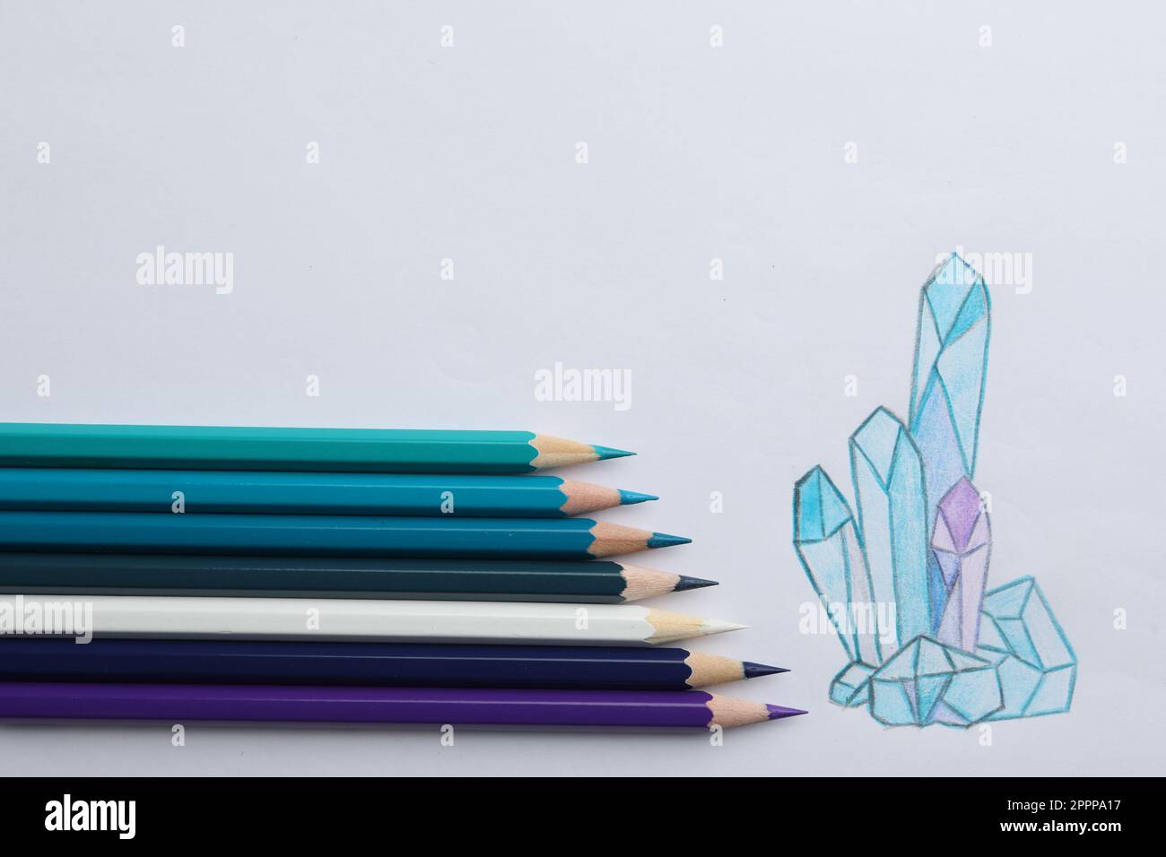 Drawing of crystals and colorful pencils on white background, top view ...
