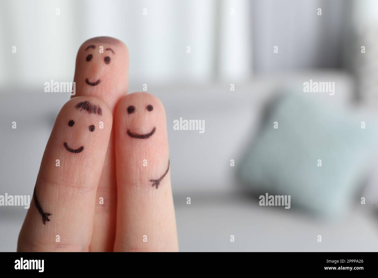 Three fingers with drawings of happy faces on blurred background, space ...