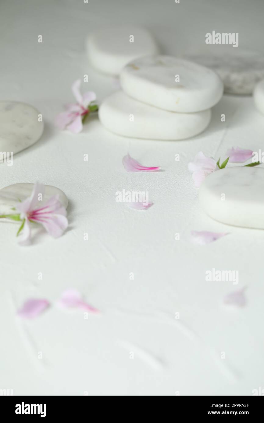 Spa stones and fresia flower on white table Stock Photo - Alamy
