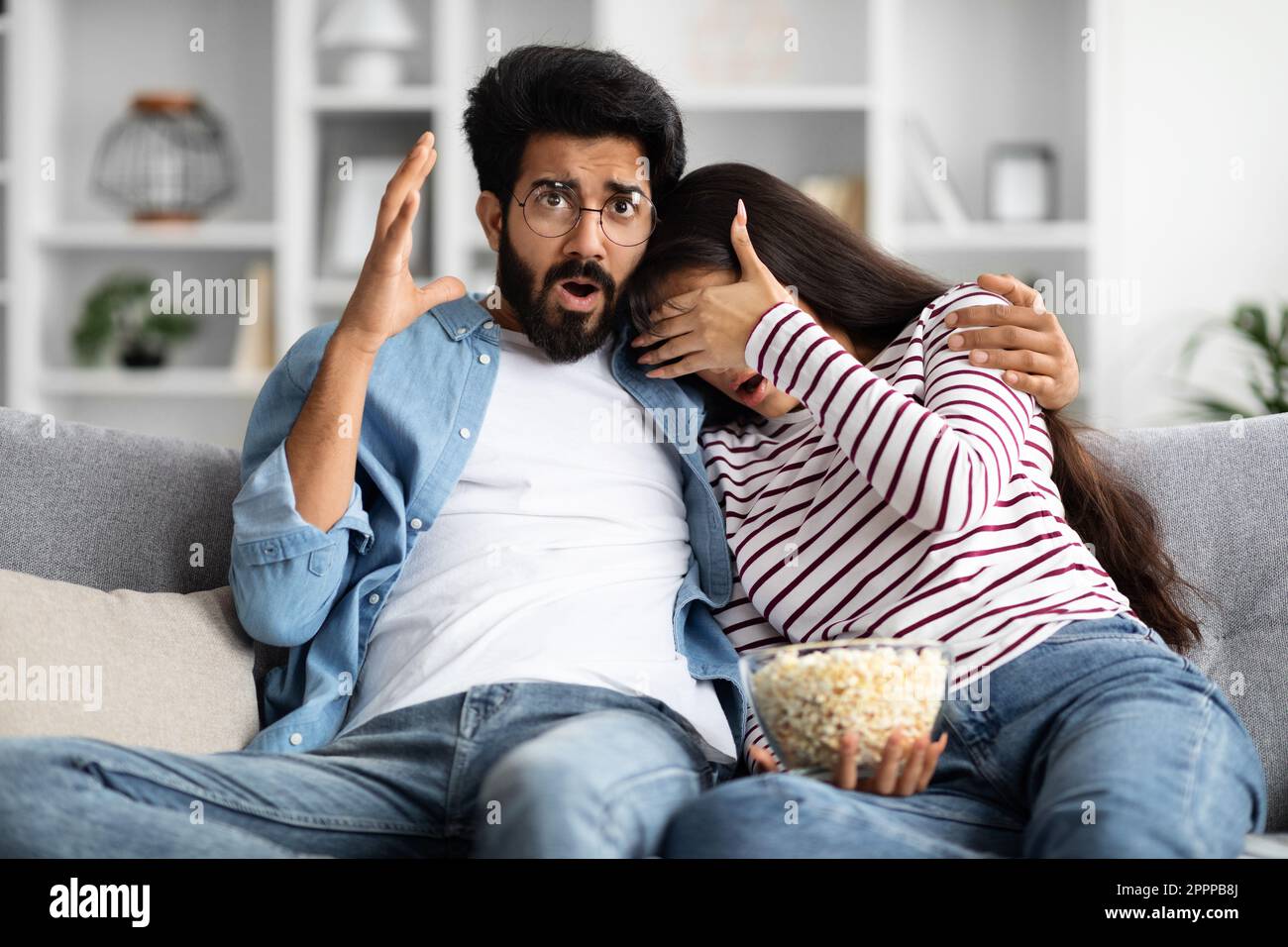 Frightened indian couple watching horror at home Stock Photo - Alamy