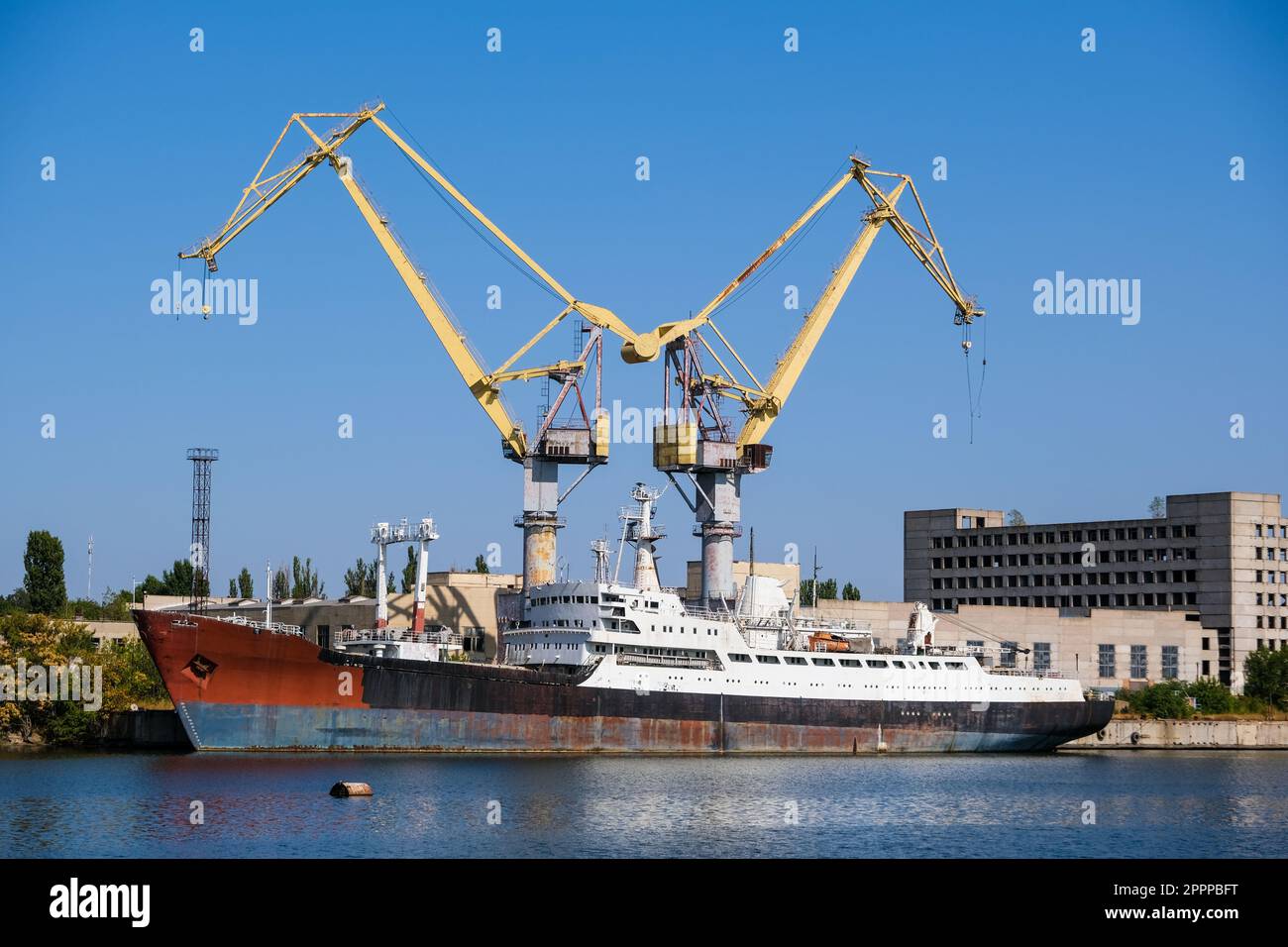 Two harbor cranes and a ship under repair at the berth Stock Photo - Alamy