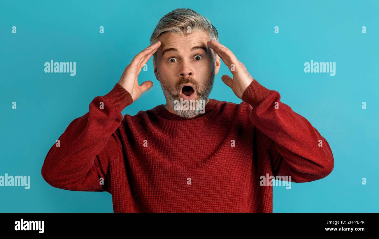 Shocked appalled middle aged man gesturing on blue background Stock ...