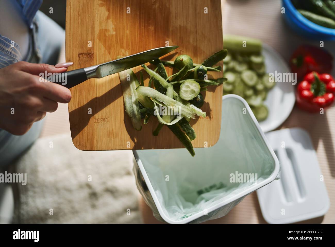 Woman throwing organic food waste in a compost bin. Female person ...