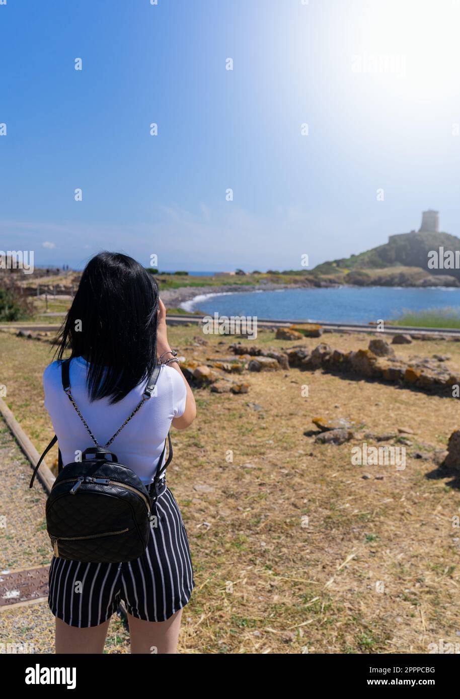 tourist photographs the ruins of Nora, an ancient Roman city in ...