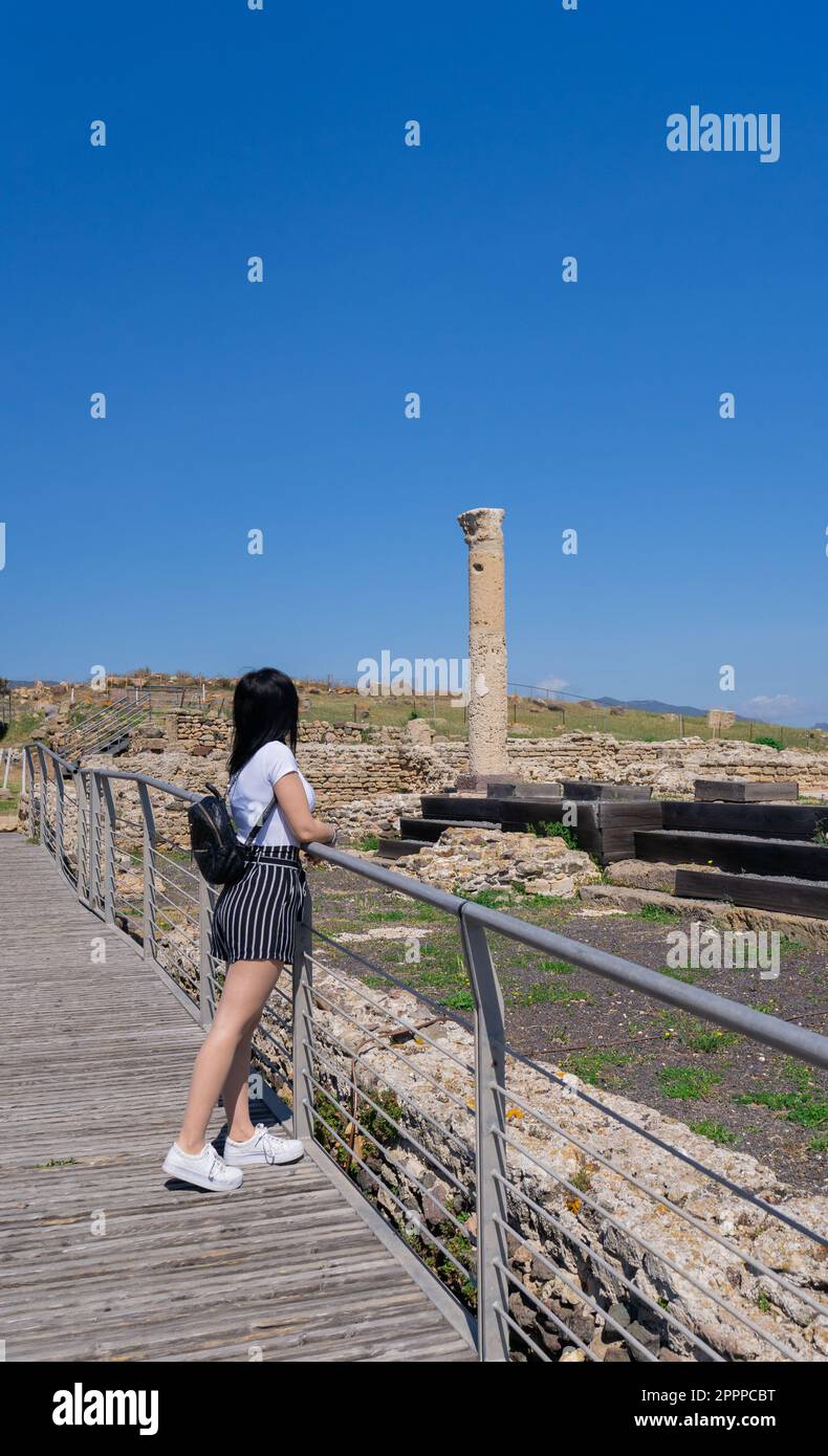 tourist photographs the ruins of Nora, an ancient Roman city in ...