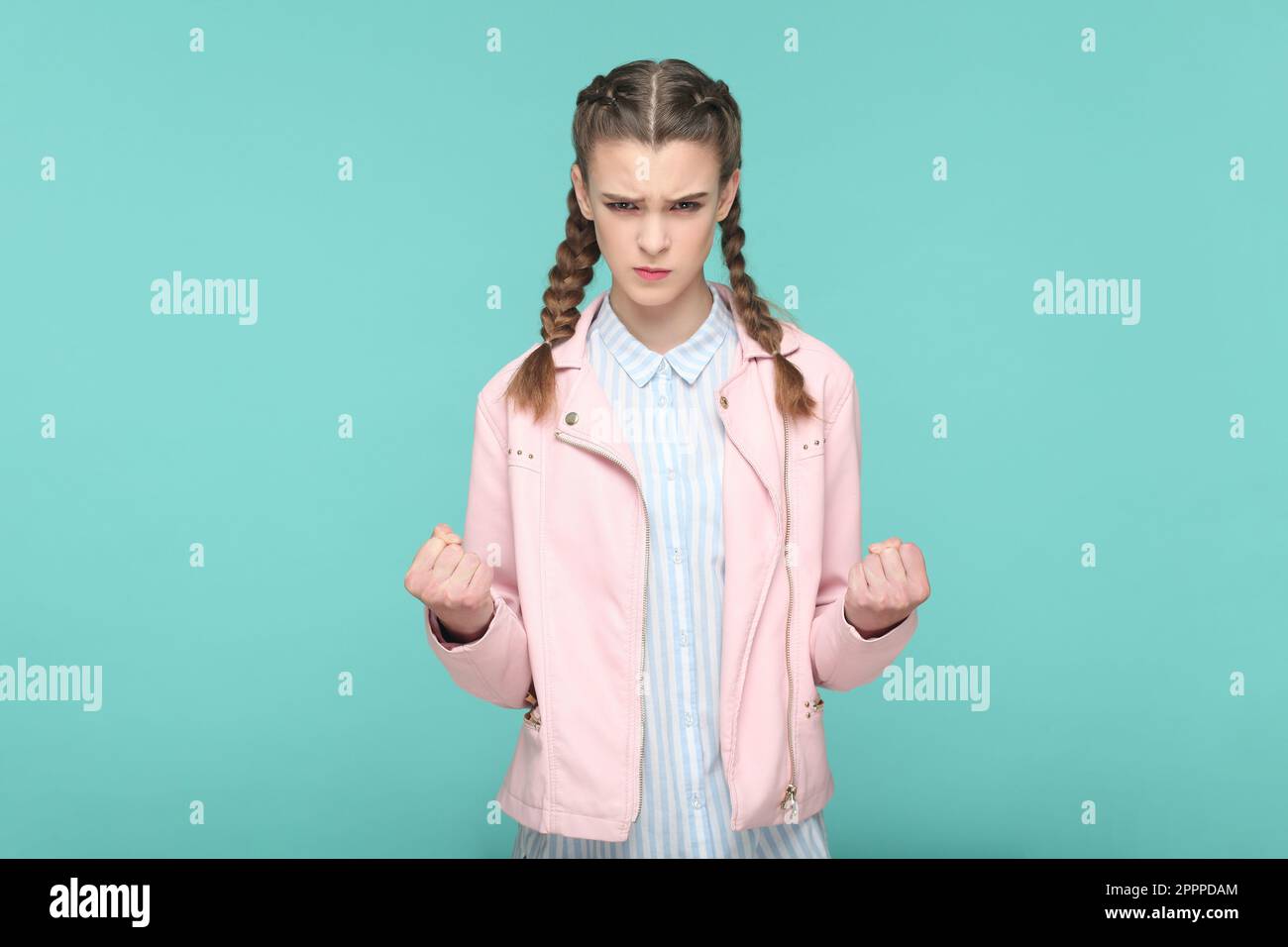 Portrait of angry aggressive attractive teenager girl with braids ...
