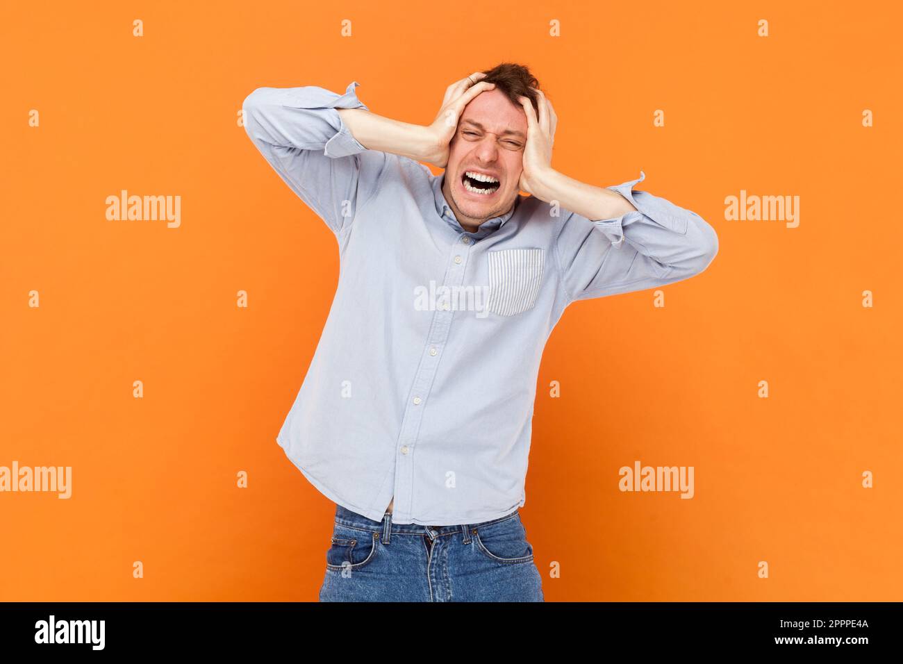 Portrait of upset sad young adult man standing with hands on head ...