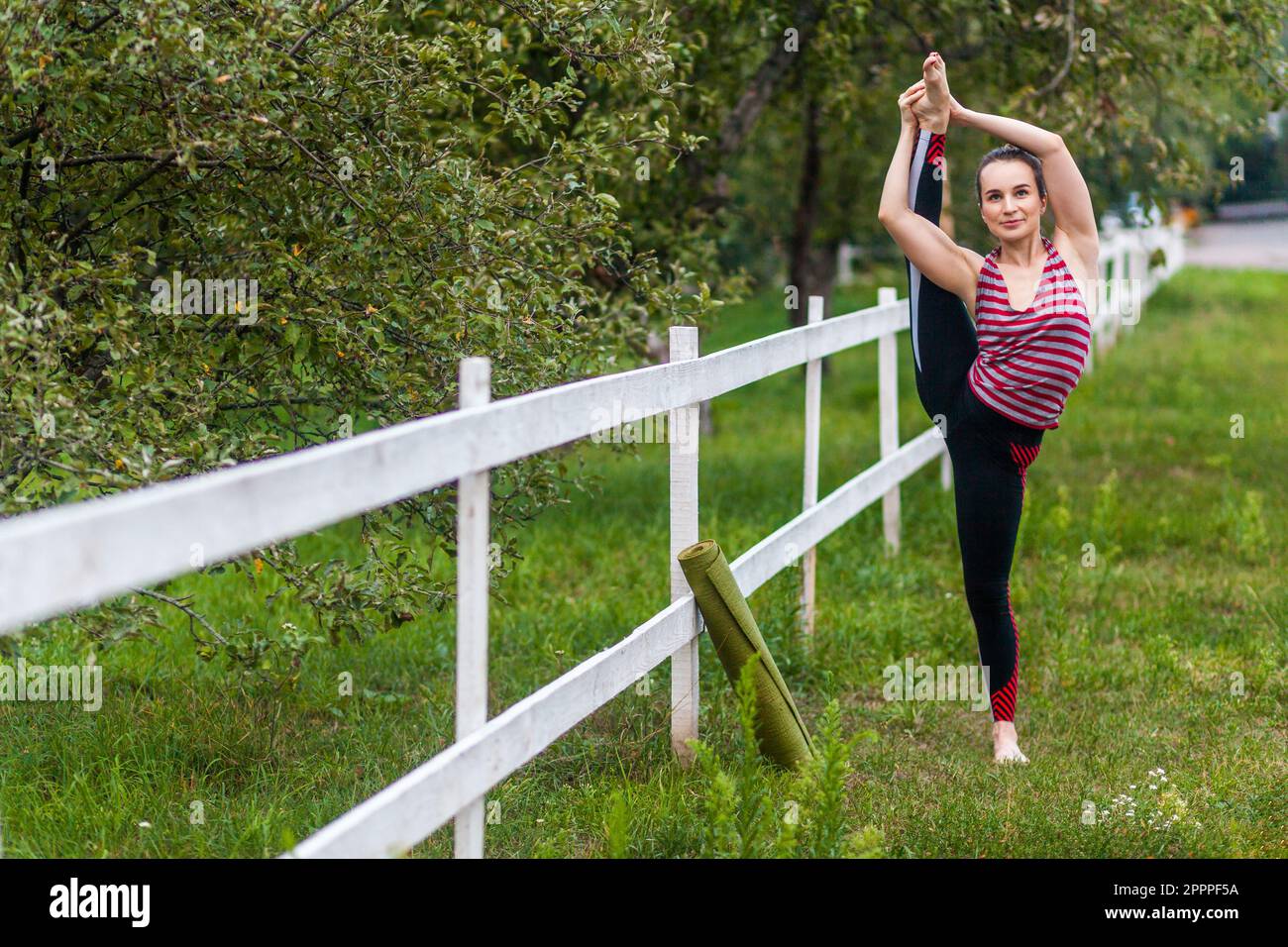 Full length portrait of flexible young woman wearing sportswear ...