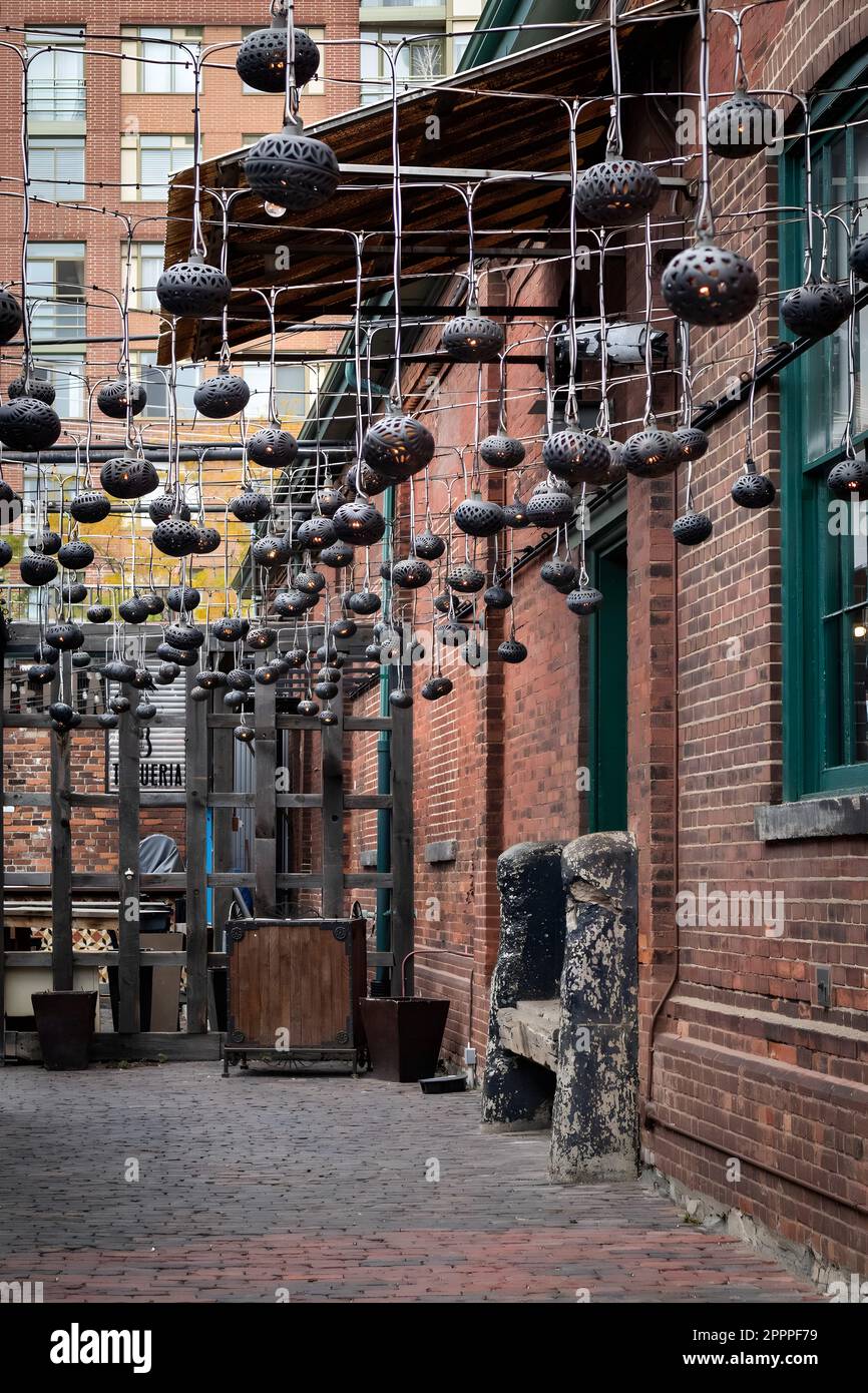 An alleyway featuring rows of hanging terracotta pots suspended from ...