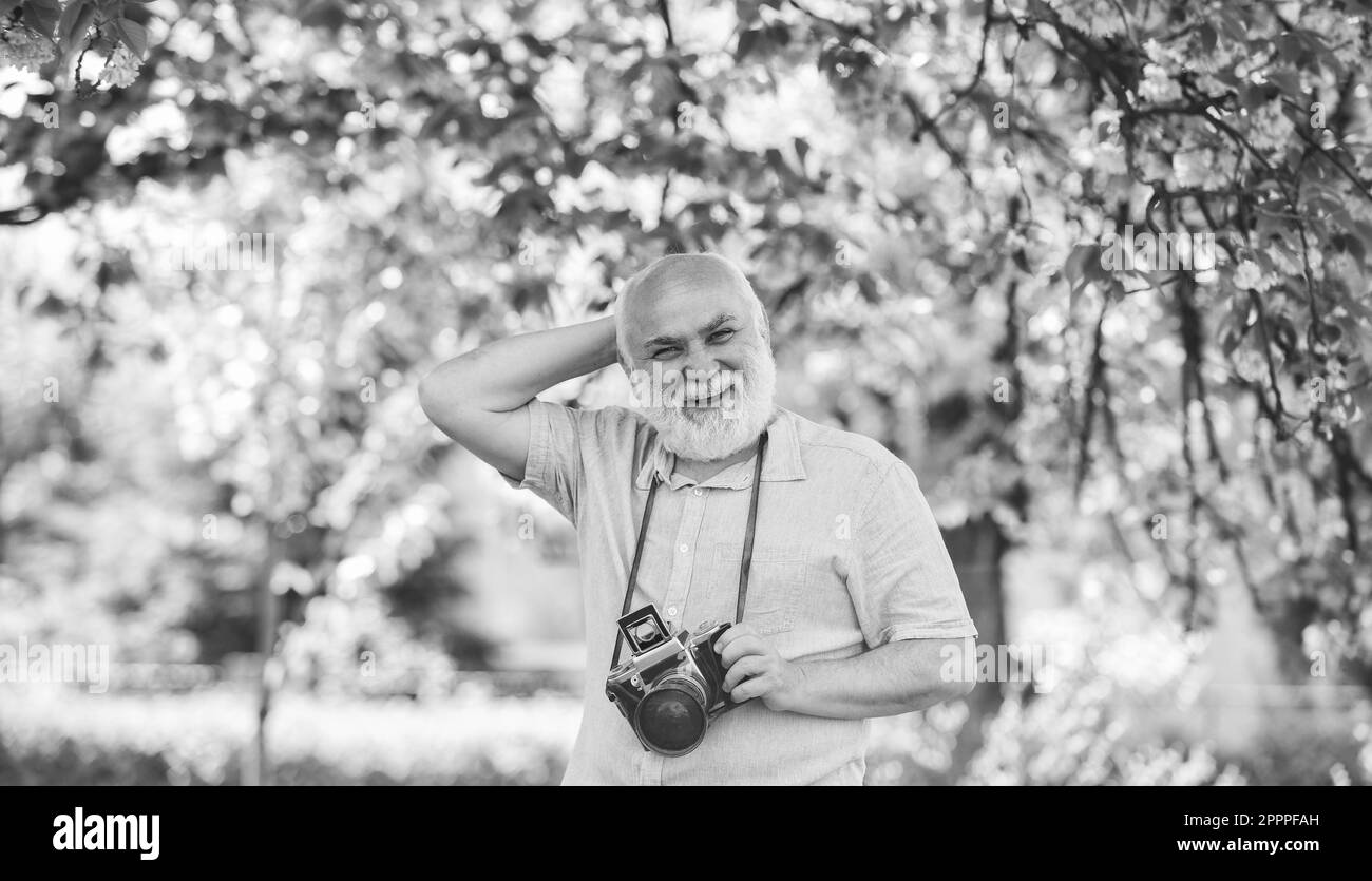 Hobby and leisure. Experienced photographer in spring garden. Cameraman ...