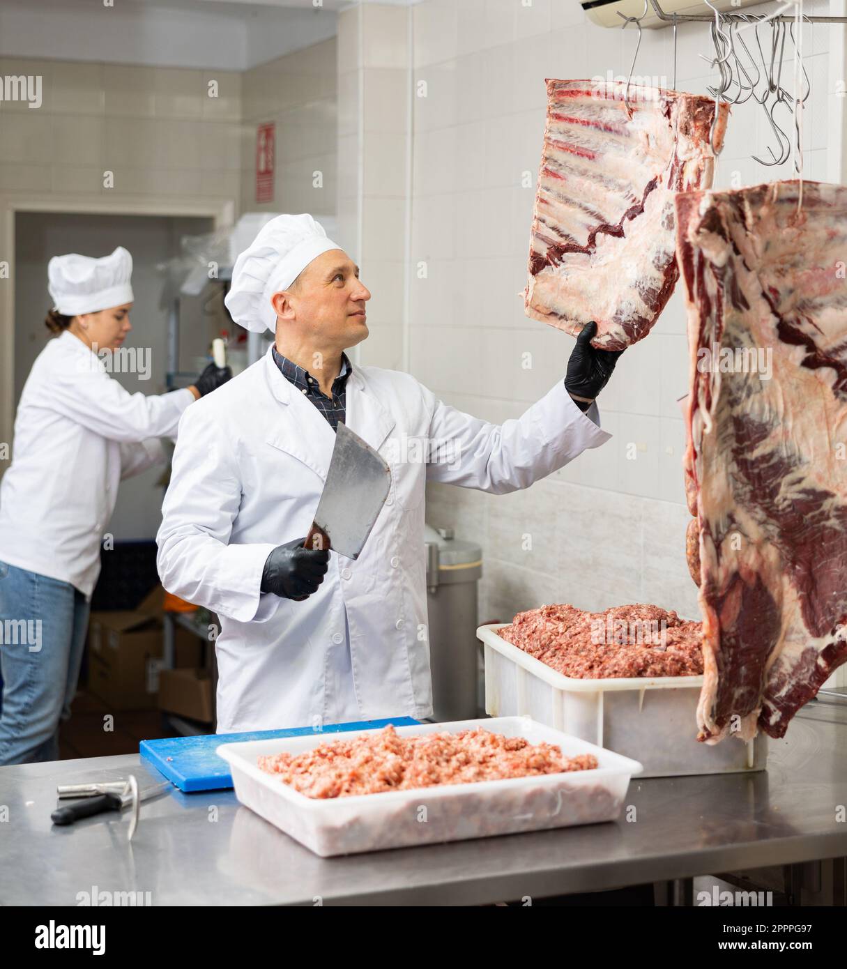 Adult male butcher holding beef ribs Stock Photo - Alamy