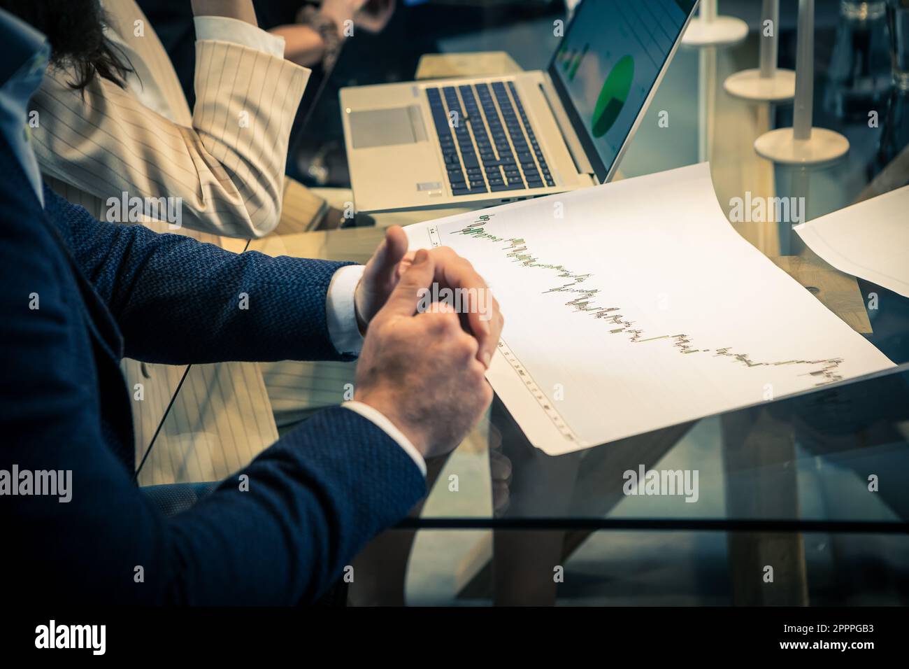 Table of entrepreneurs with selective focus on a trading graph ...