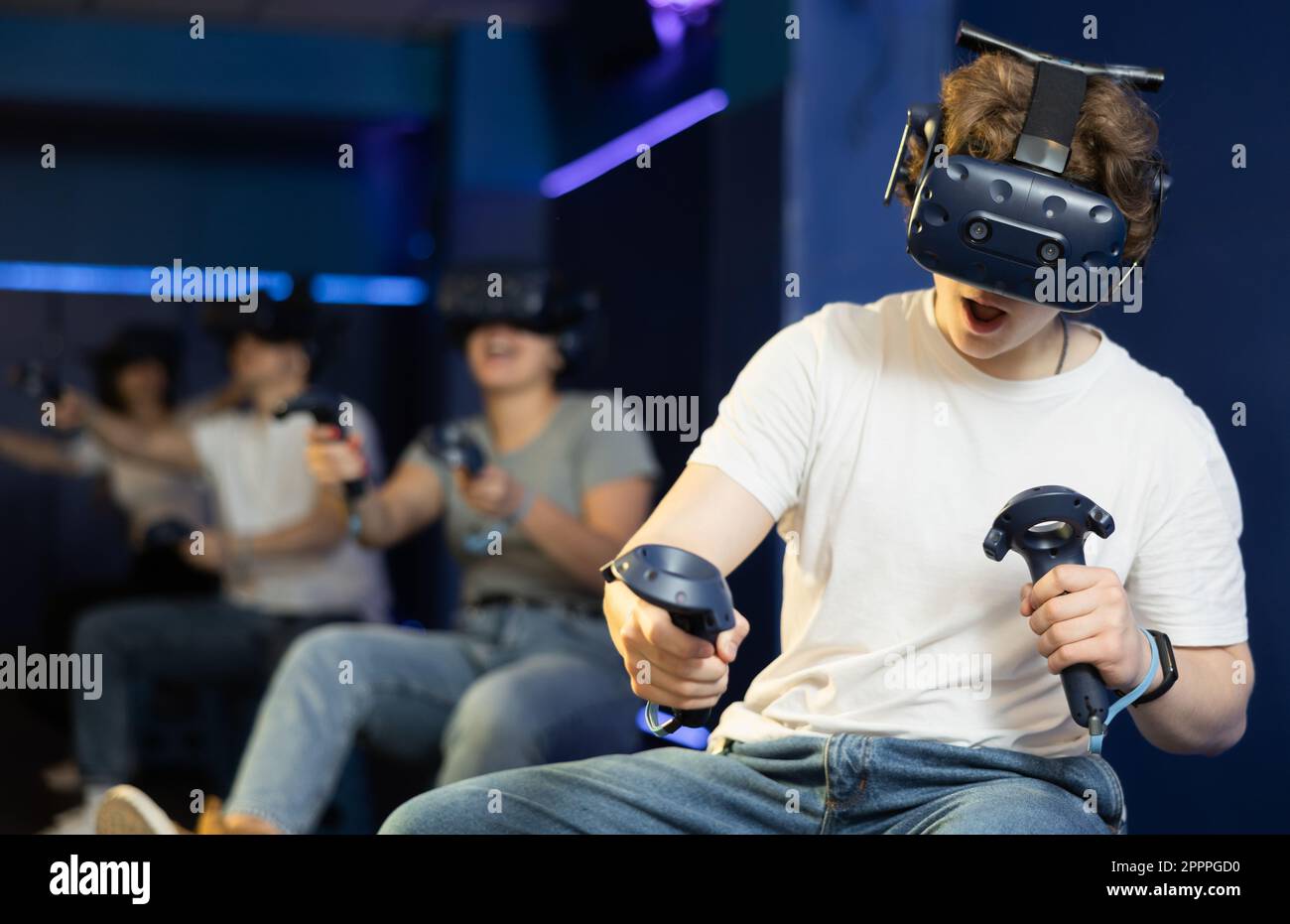 Guy with handheld controllers and VR glasses playing virtual game Stock ...