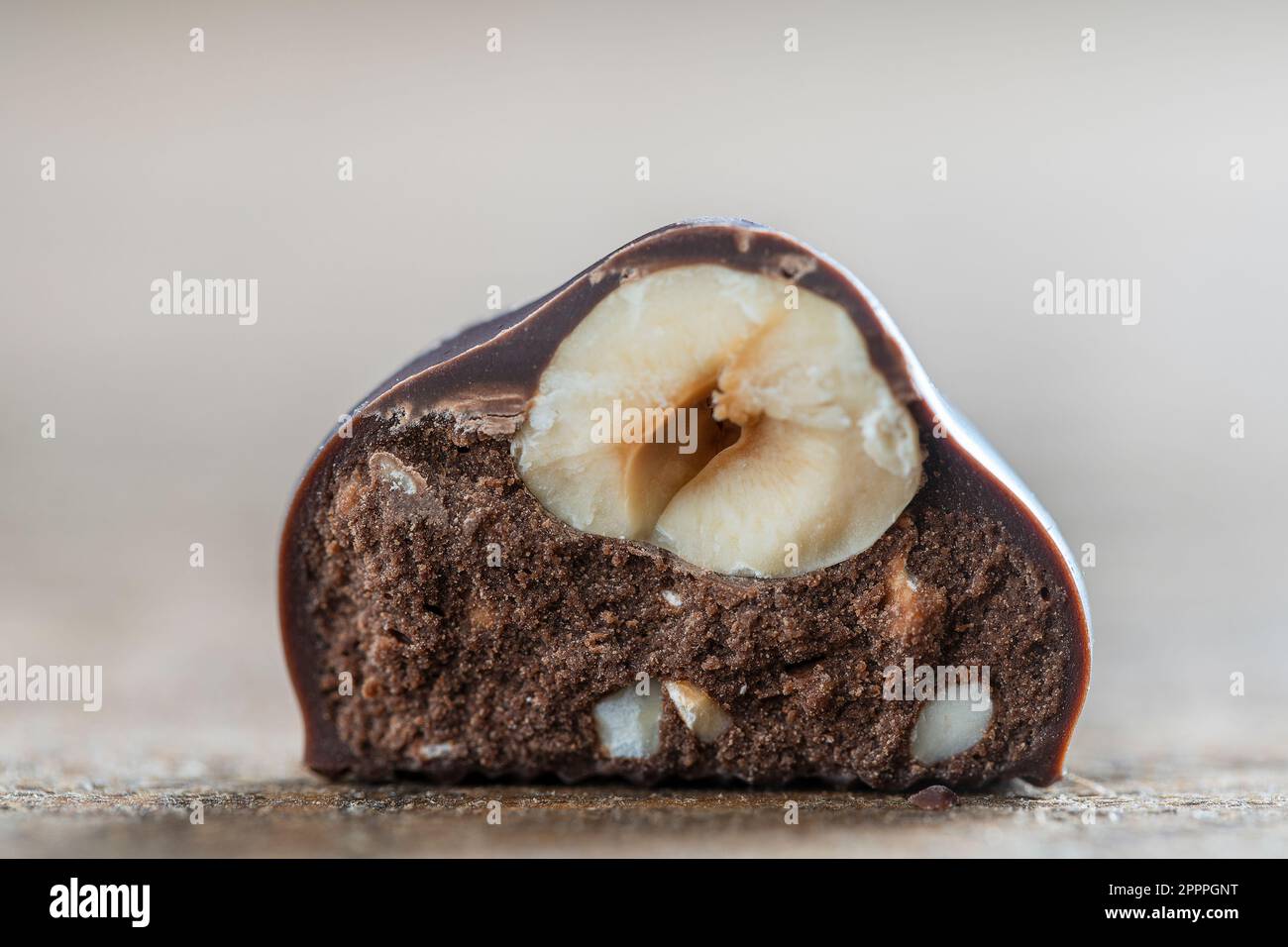 Half chocolate truffle centre topped with a whole hazelnut, close up ...
