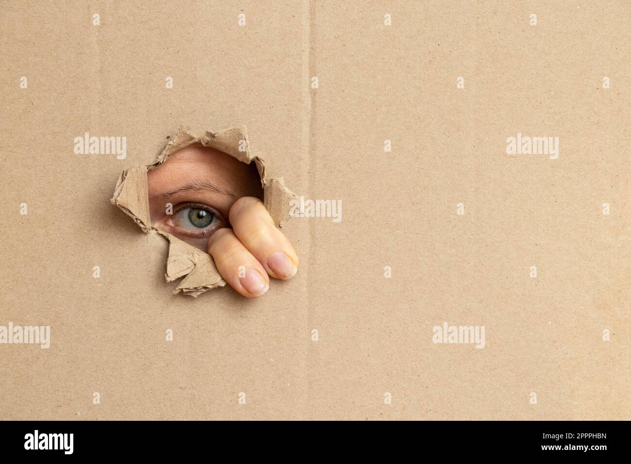 The girl's eye looks into the cardboard hole, look Stock Photo - Alamy