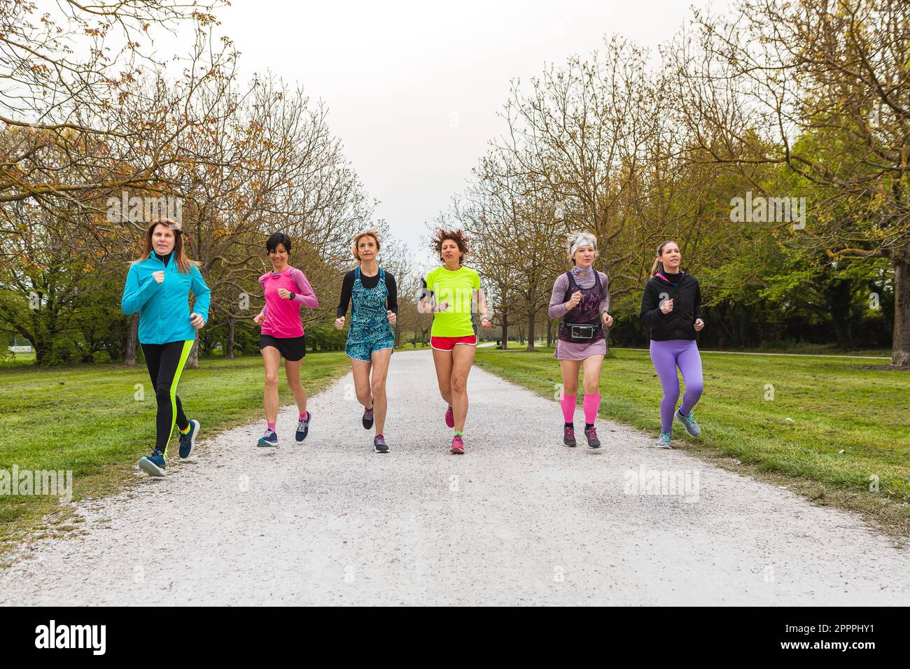 Group of female runners running in a park. Mature women exercising ...