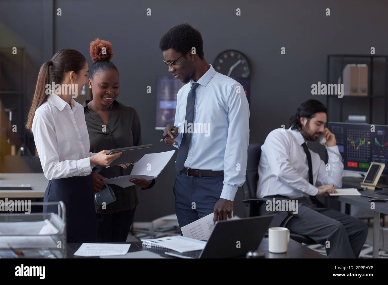 Group of young brokers discussing financial stock market together ...