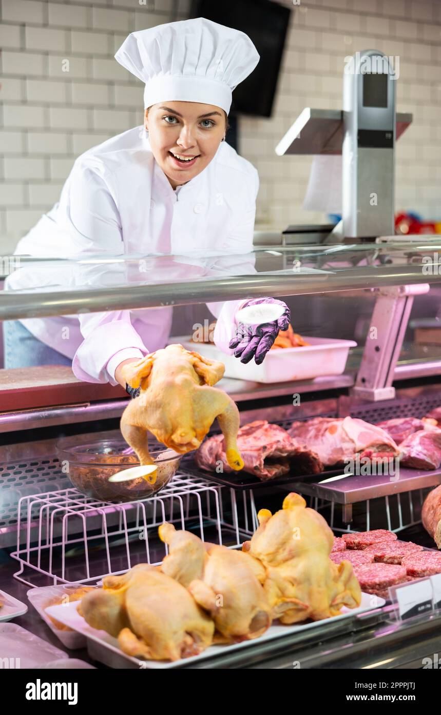Young female butcher offering fresh raw chickens Stock Photo - Alamy