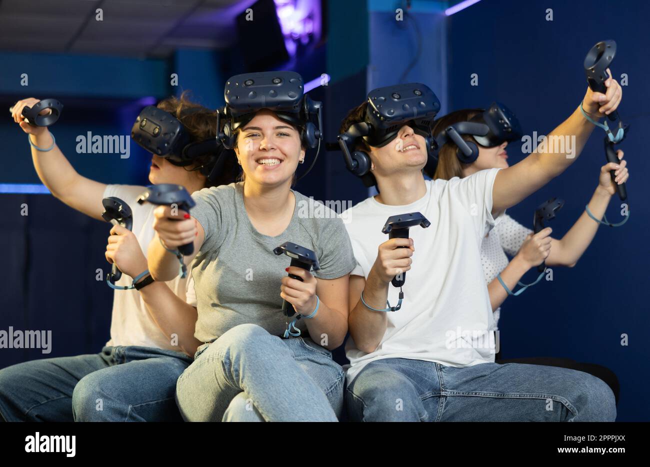 Female student with vr headset on forehead and analog stick sits next ...