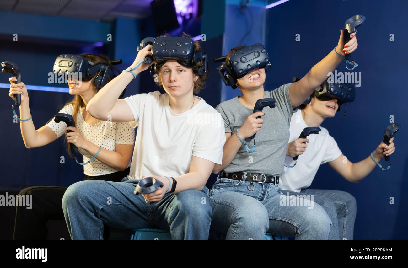 Female student with vr headset on forehead and analog stick sits next ...