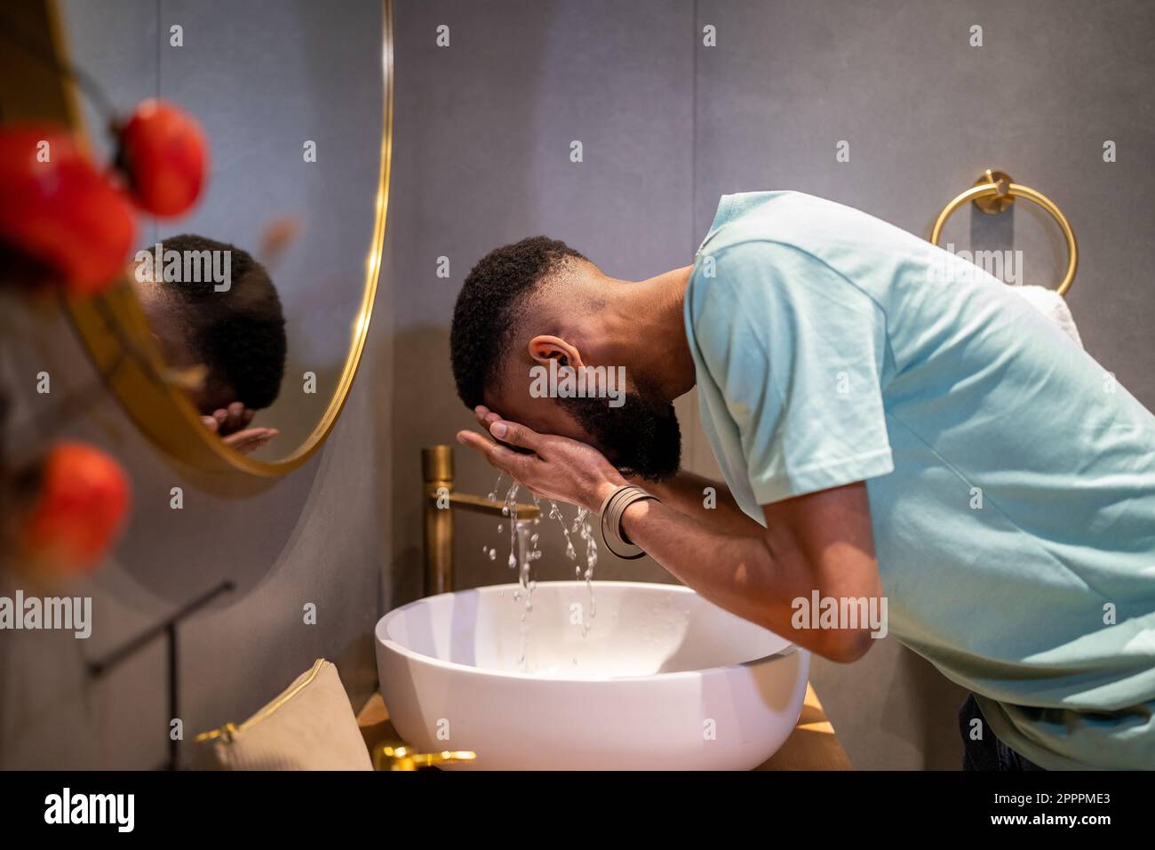African American millennial guy cleaning skin in morning, washing face ...