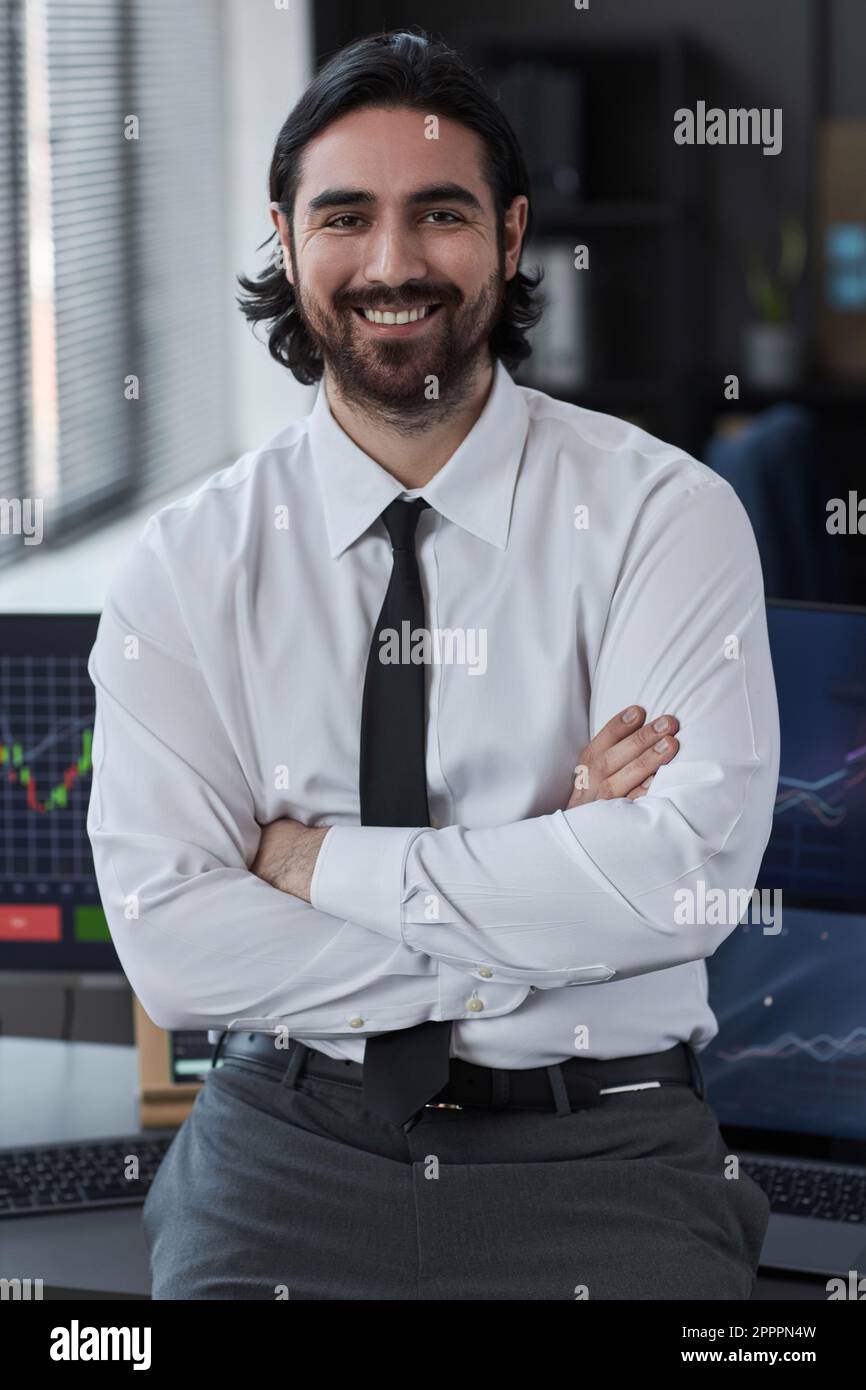 Vertical image of successful trader smiling at camera standing near his ...